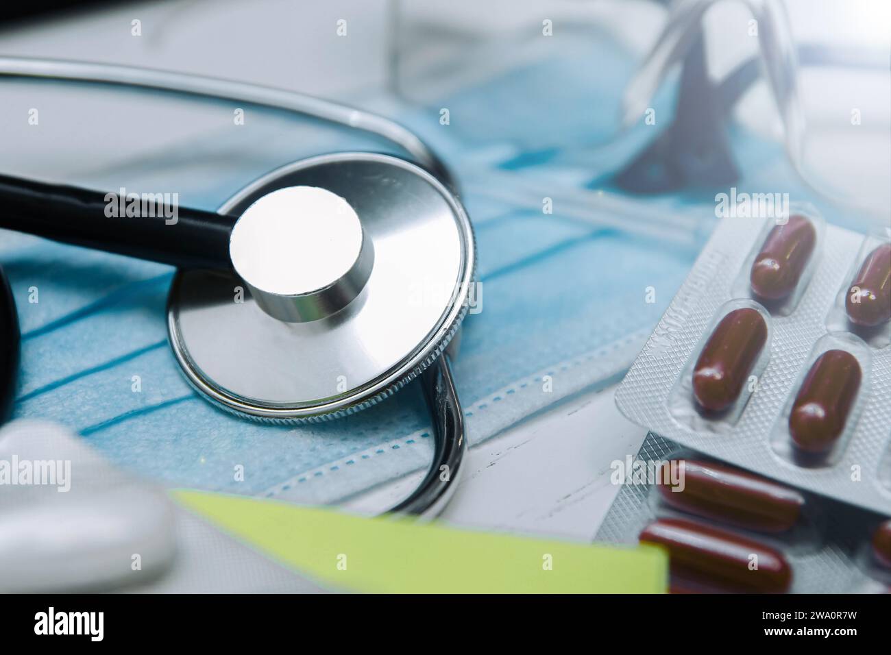 Doctor's desk close-up: phonendoscope, sticky notes, tablets, safety ...