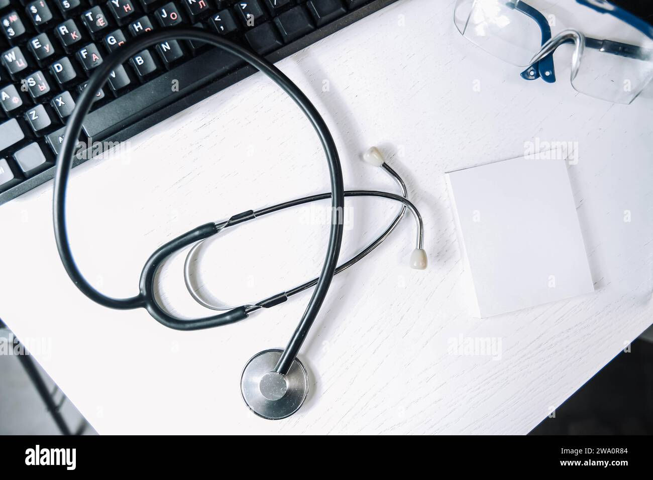 Doctor's desk: phonendoscope, keyboard, sticky notes Stock Photo - Alamy