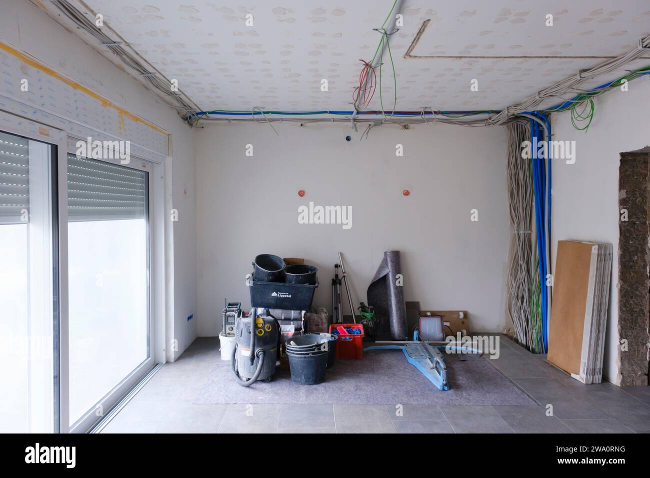 Room with newly laid electrical cables, fresh plaster on the wall ...