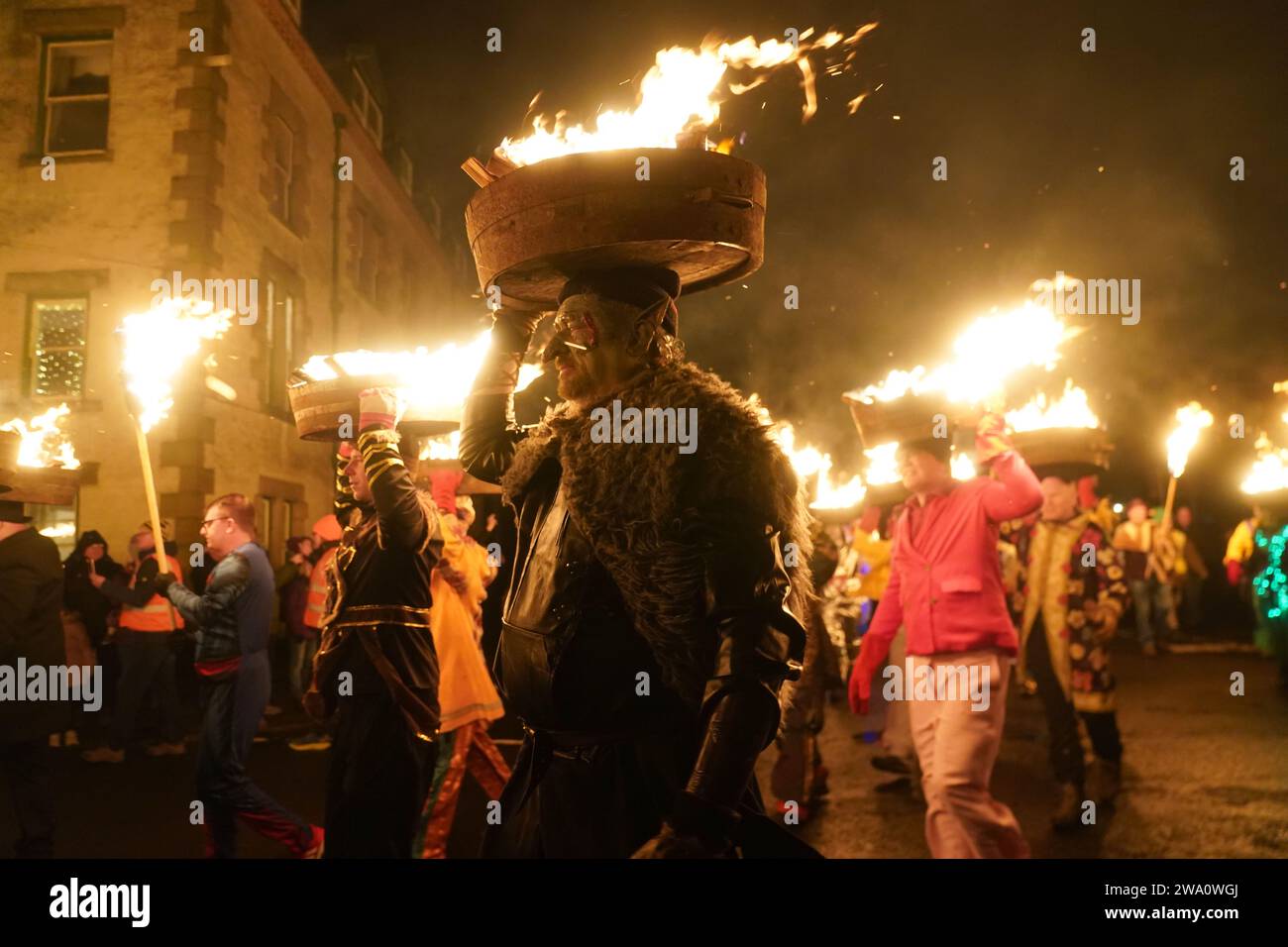 Men, known as guisers, carry burning whisky barrels through the streets ...