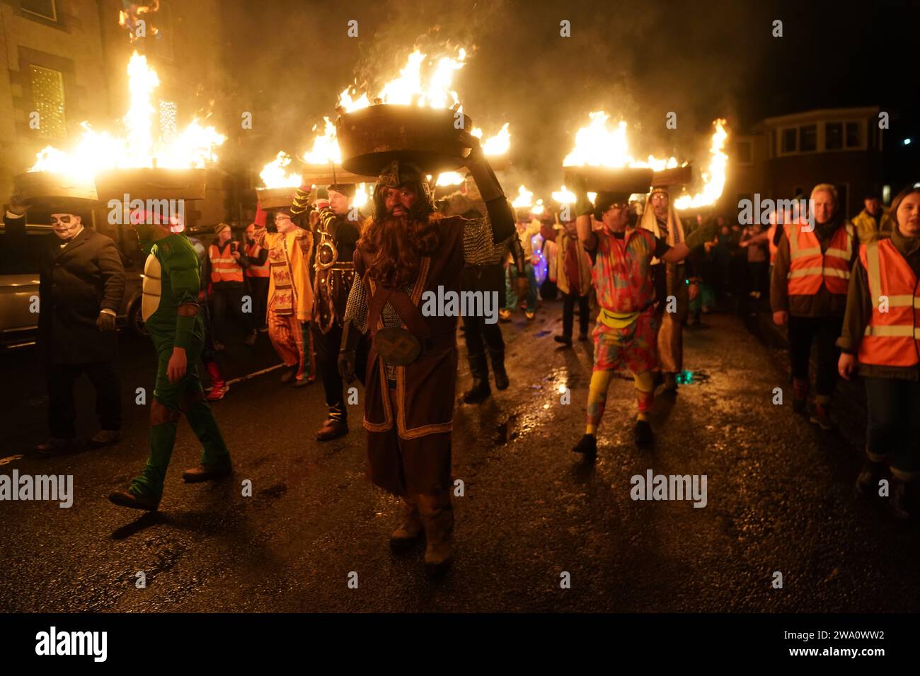 Men, known as guisers, carry burning whisky barrels through the streets ...