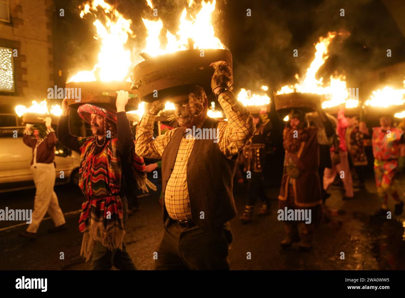 Men, known as guisers, carry burning whisky barrels through the streets ...