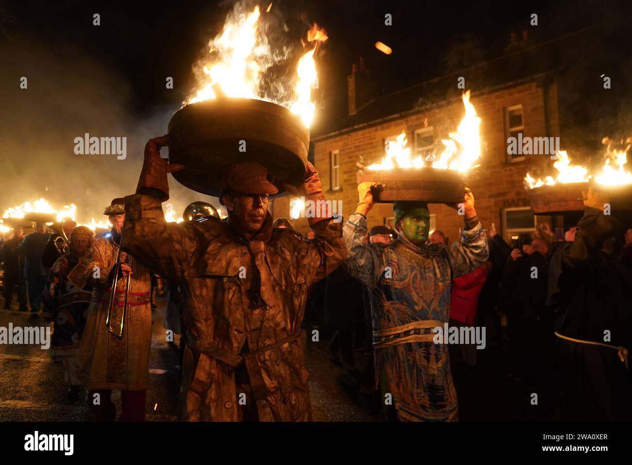 Men, known as guisers, carry burning whisky barrels through the streets ...