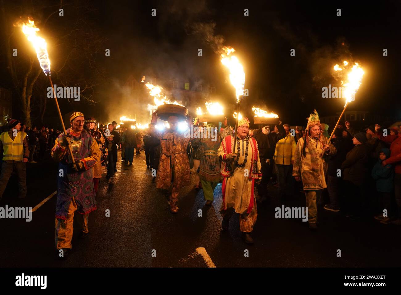 Men, known as guisers, carry burning whisky barrels through the streets ...