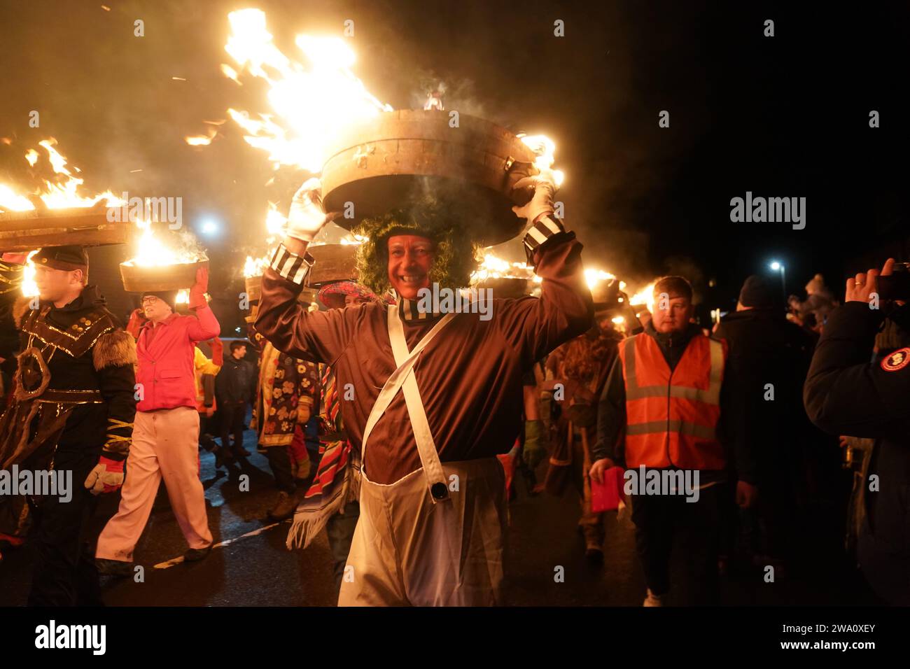 Men, known as guisers, carry burning whisky barrels through the streets ...