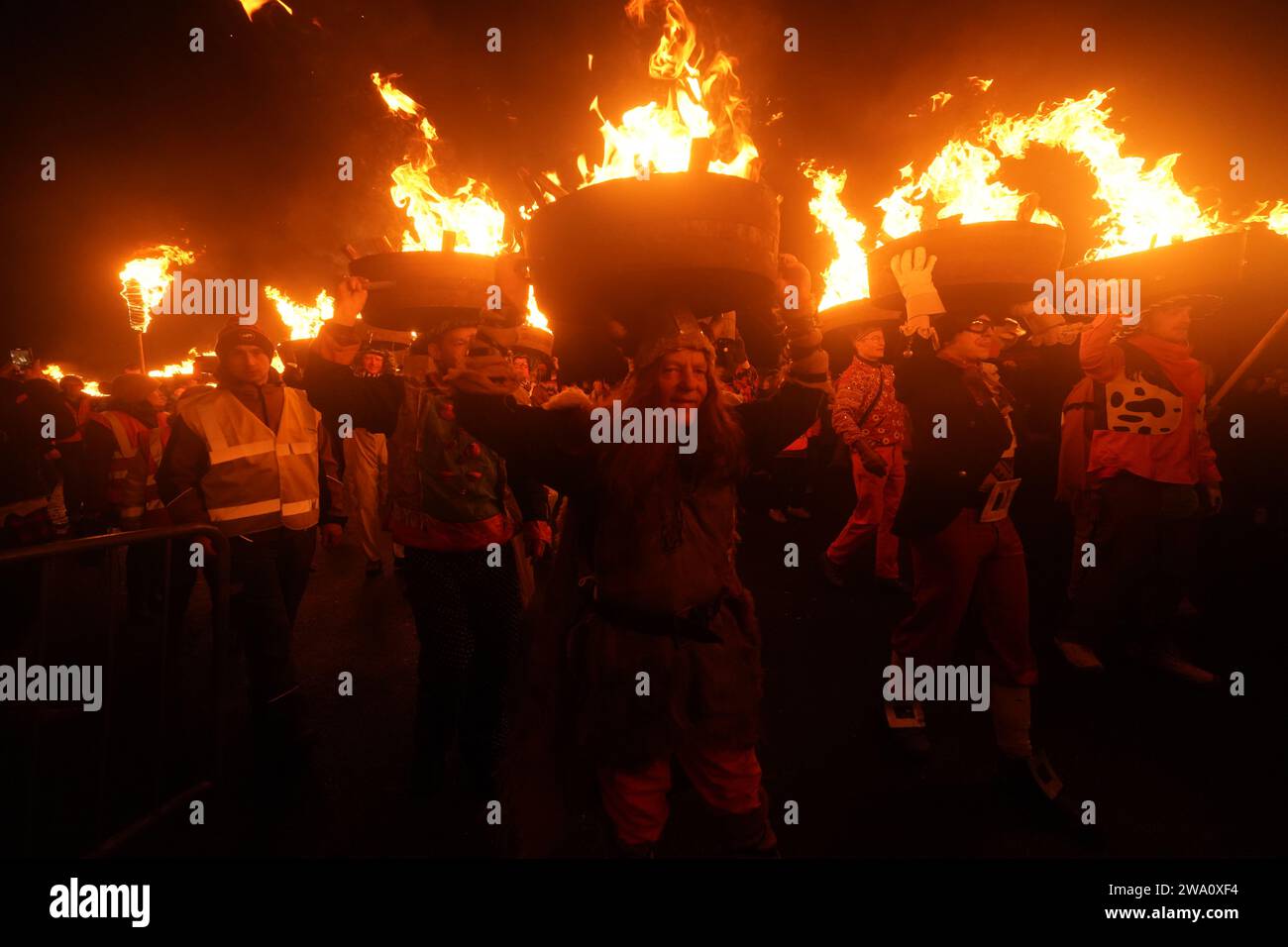 Men, known as guisers, carry burning whisky barrels through the streets ...