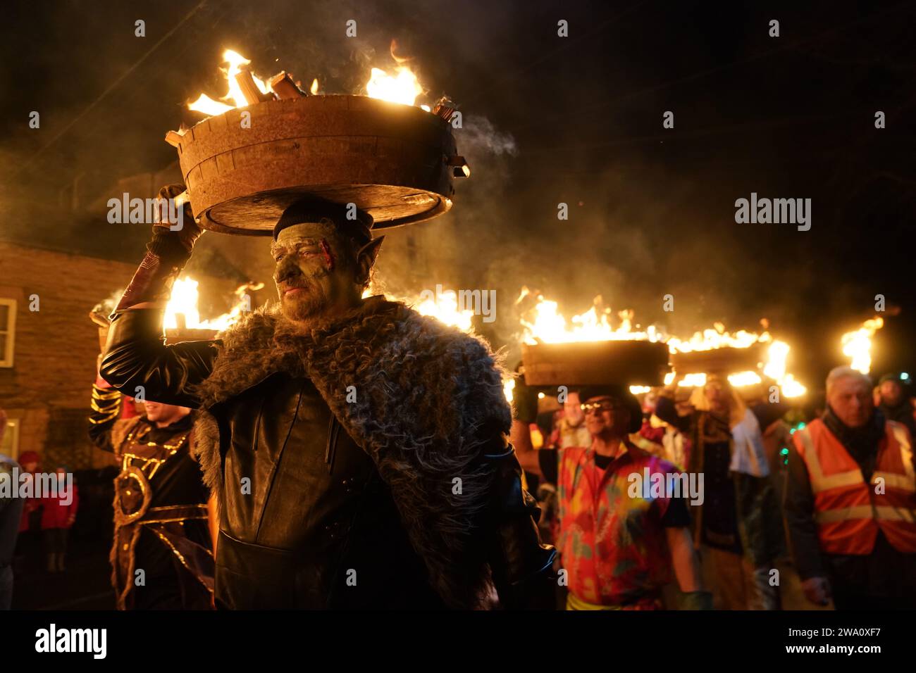 Men, known as guisers, carry burning whisky barrels through the streets ...