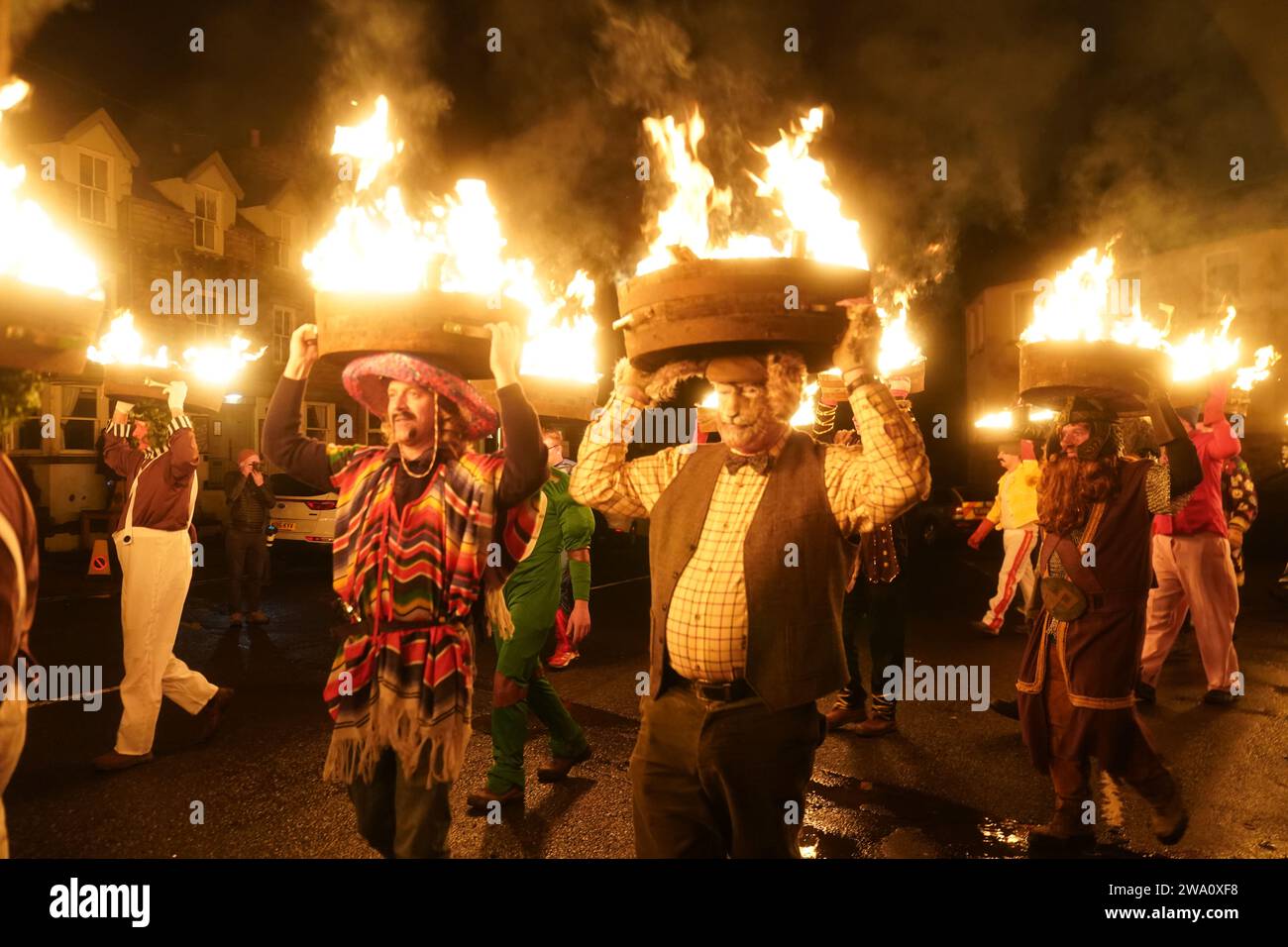 Men, known as guisers, carry burning whisky barrels through the streets ...