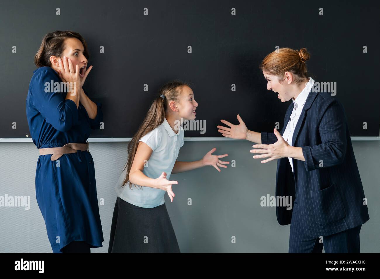The teacher screams at the schoolgirl and her mother standing at the ...