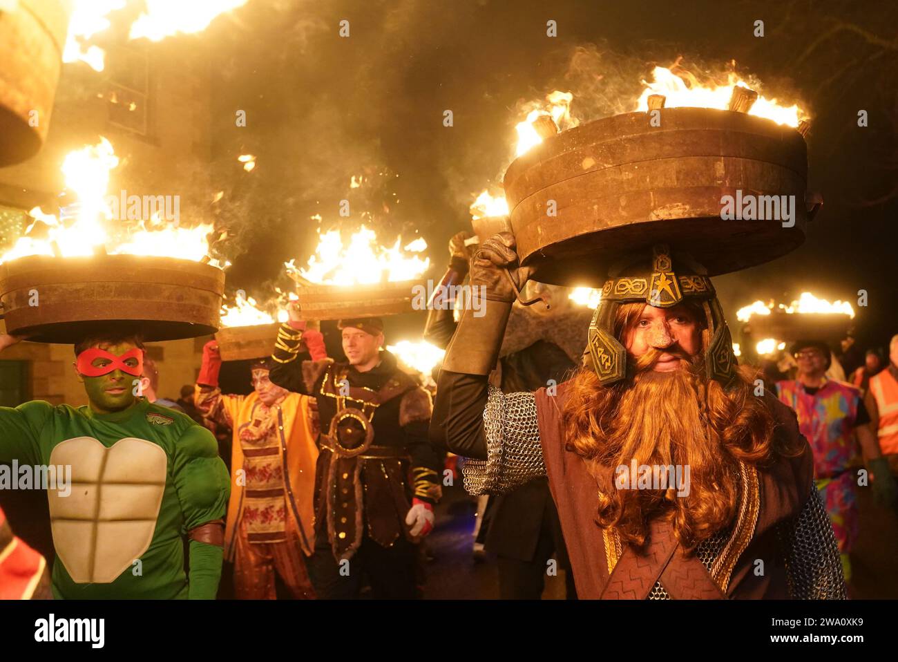 Men, known as guisers, carry burning whisky barrels through the streets ...
