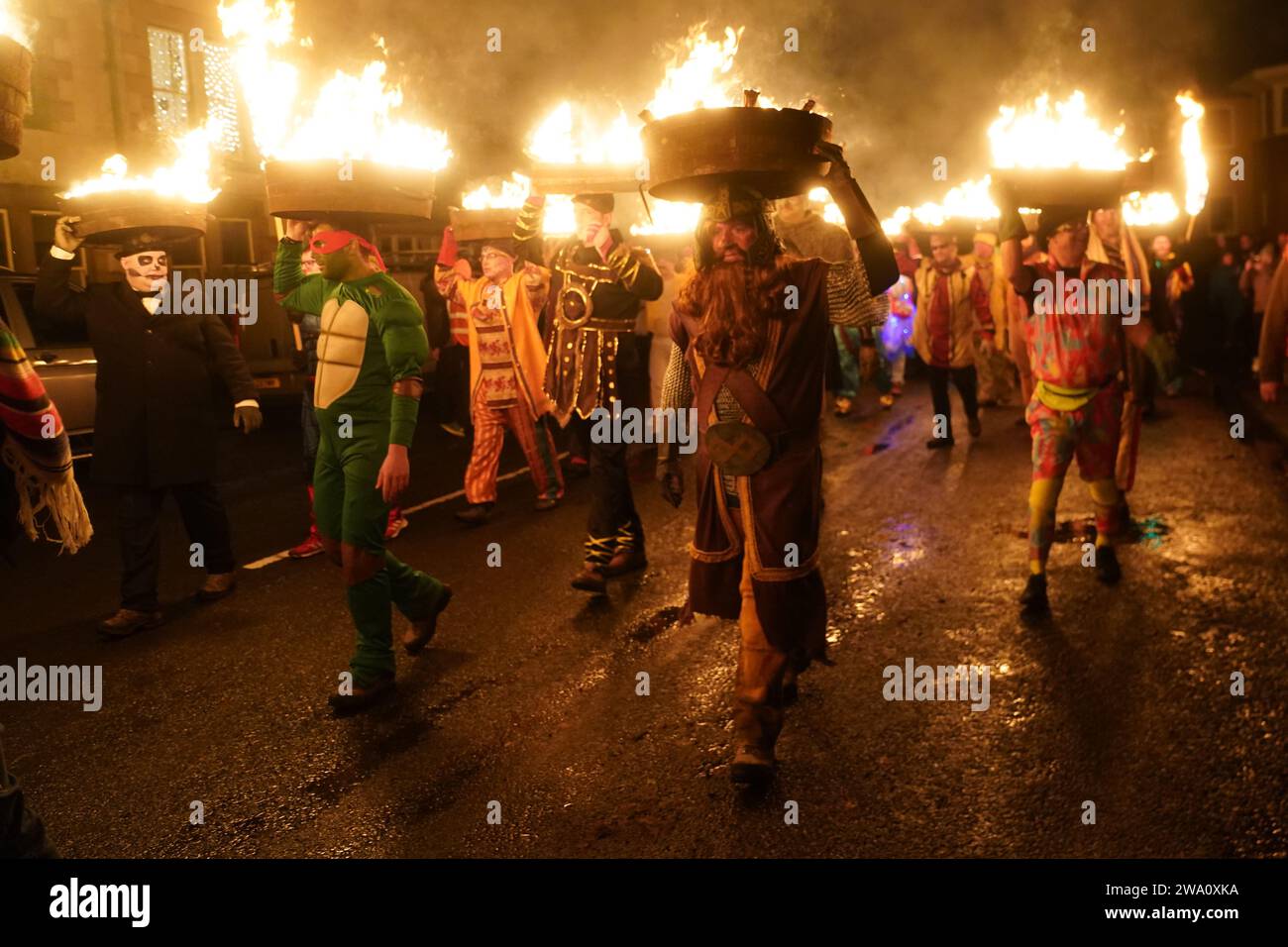Men, known as guisers, carry burning whisky barrels through the streets ...