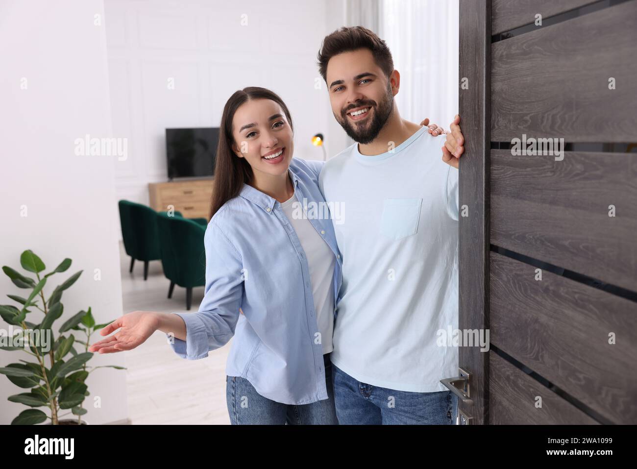 Happy couple welcoming near door. Invitation to come indoors Stock ...