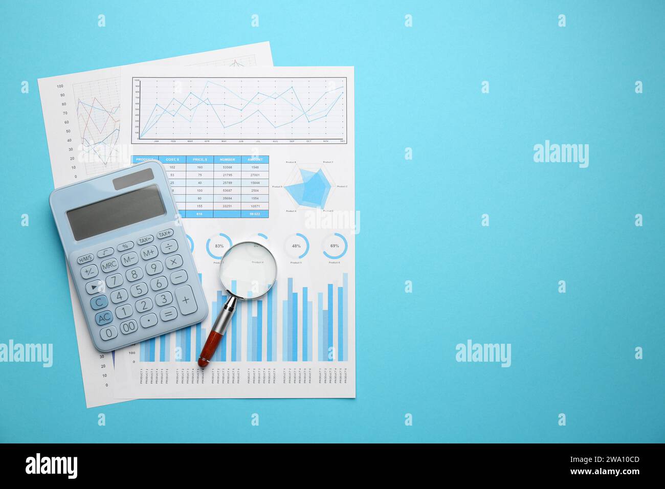 Accounting documents, magnifying glass and calculator on light blue ...
