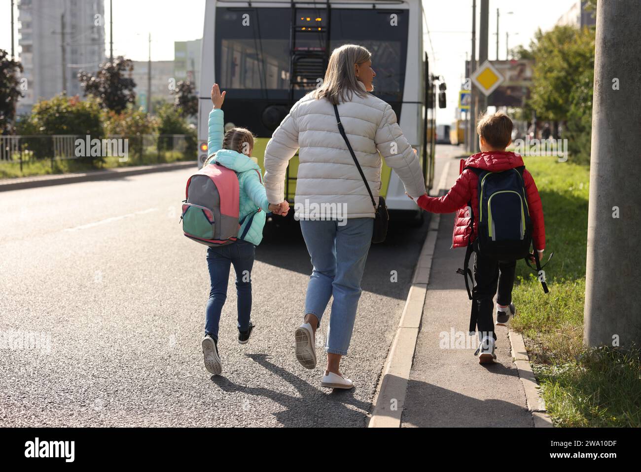 Being late for school. Senior woman and her grandchildren with ...