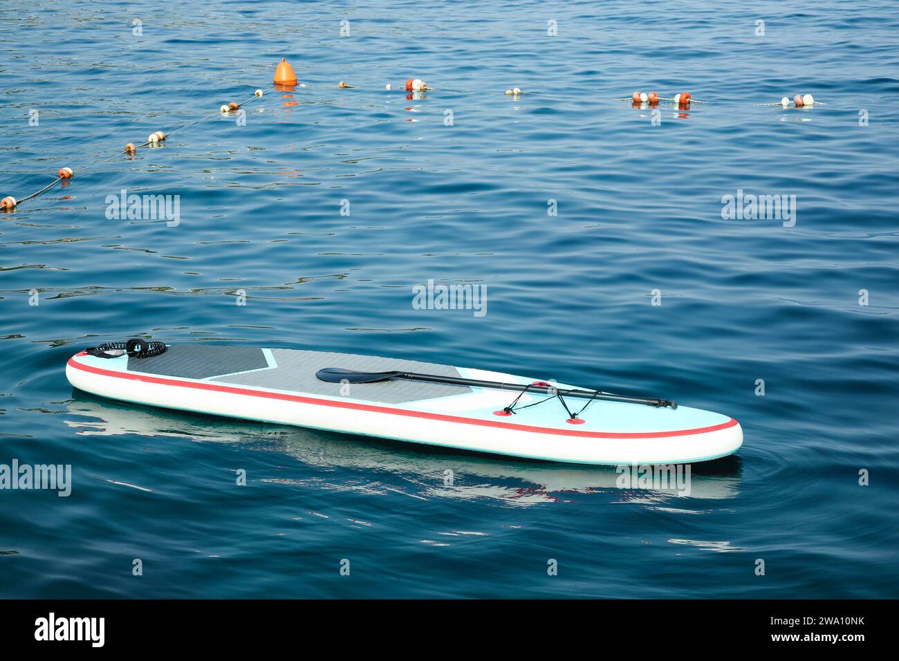 One SUP board with paddle on water in sea Stock Photo - Alamy