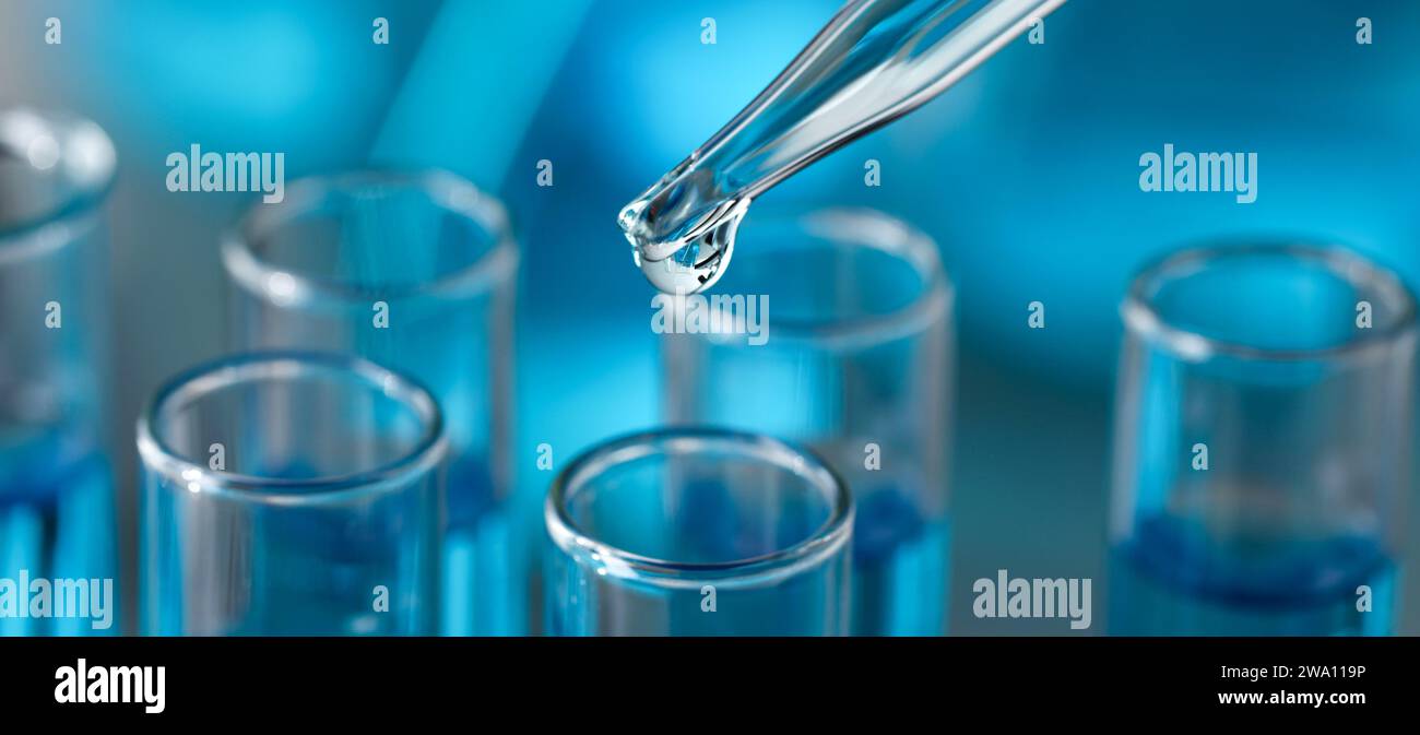 Laboratory analysis. Dripping reagent into test tube against blurred ...