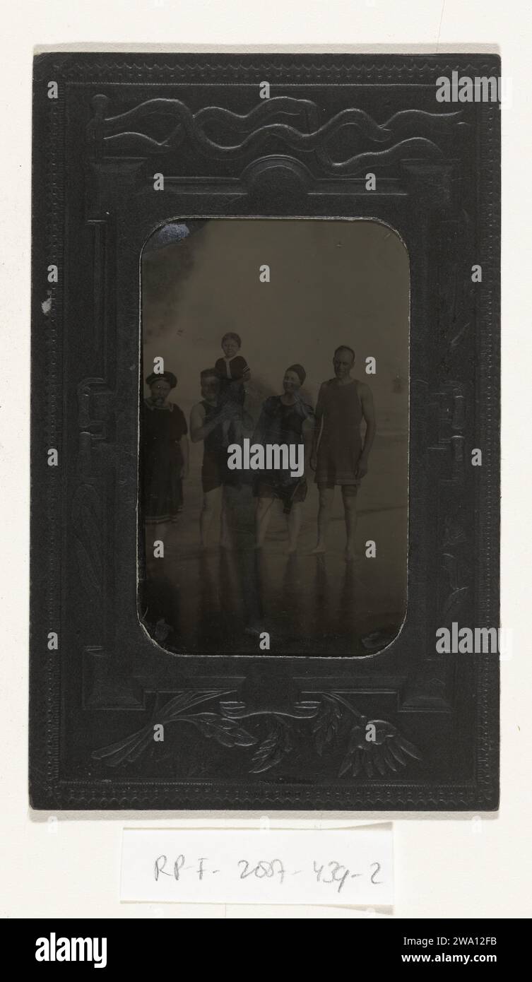 Group portrait of two men, two women and a boy on the beach, with the ...