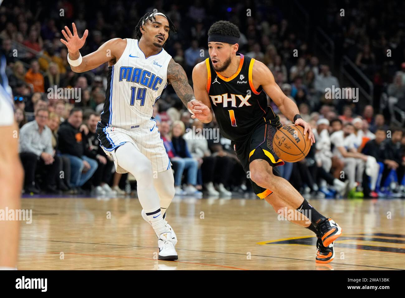 Phoenix Suns guard Devin Booker (1) drives on Orlando Magic guard Gary Harris (14) during the ...