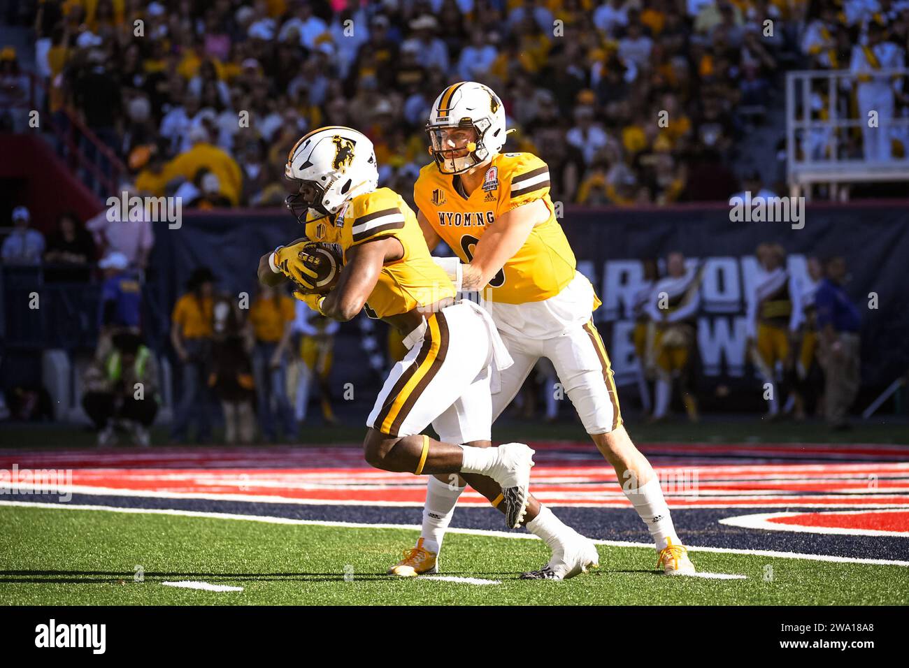 Wyoming Cowboys quarterback Andrew Peasley (6) hands off to running ... Wyoming Cowboys quarterback Andrew Peasley (6) hands off to running ...