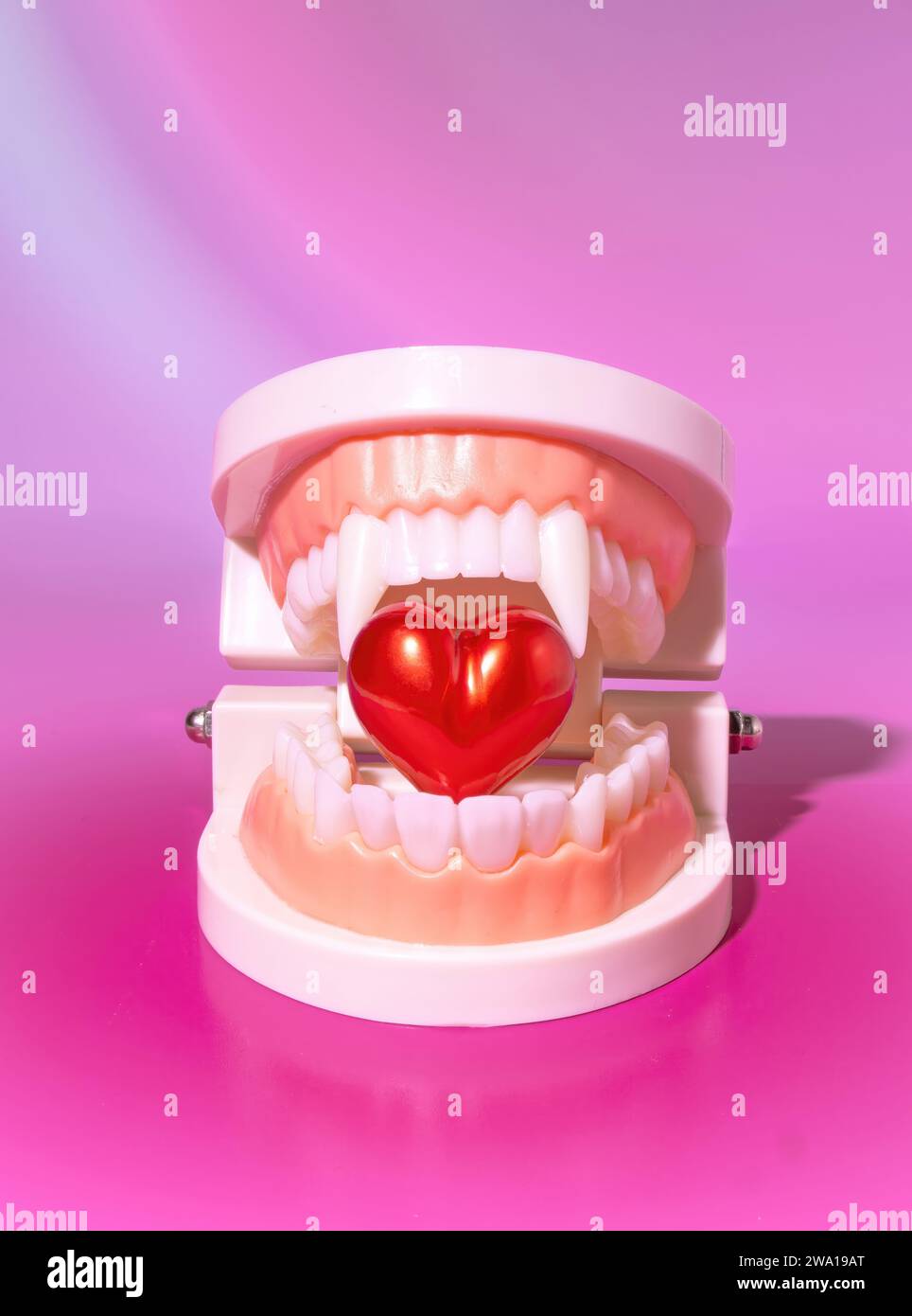 A Vampire Mouth with Sharp Fangs Biting on a Bright Red Heart Stock ...