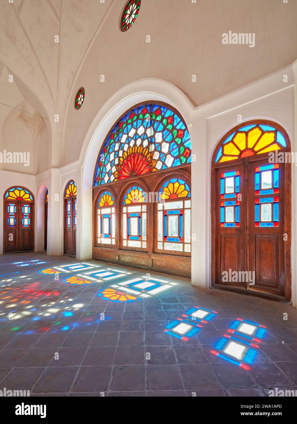Room with colorful stained glass windows in the Tabatabaei House, a ...