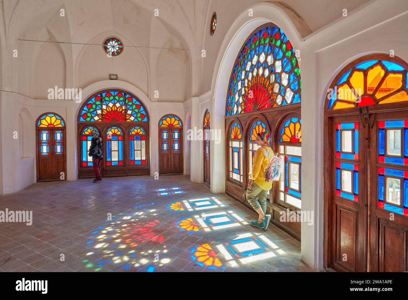 Room with colorful stained glass windows in the Tabatabaei House, a ...