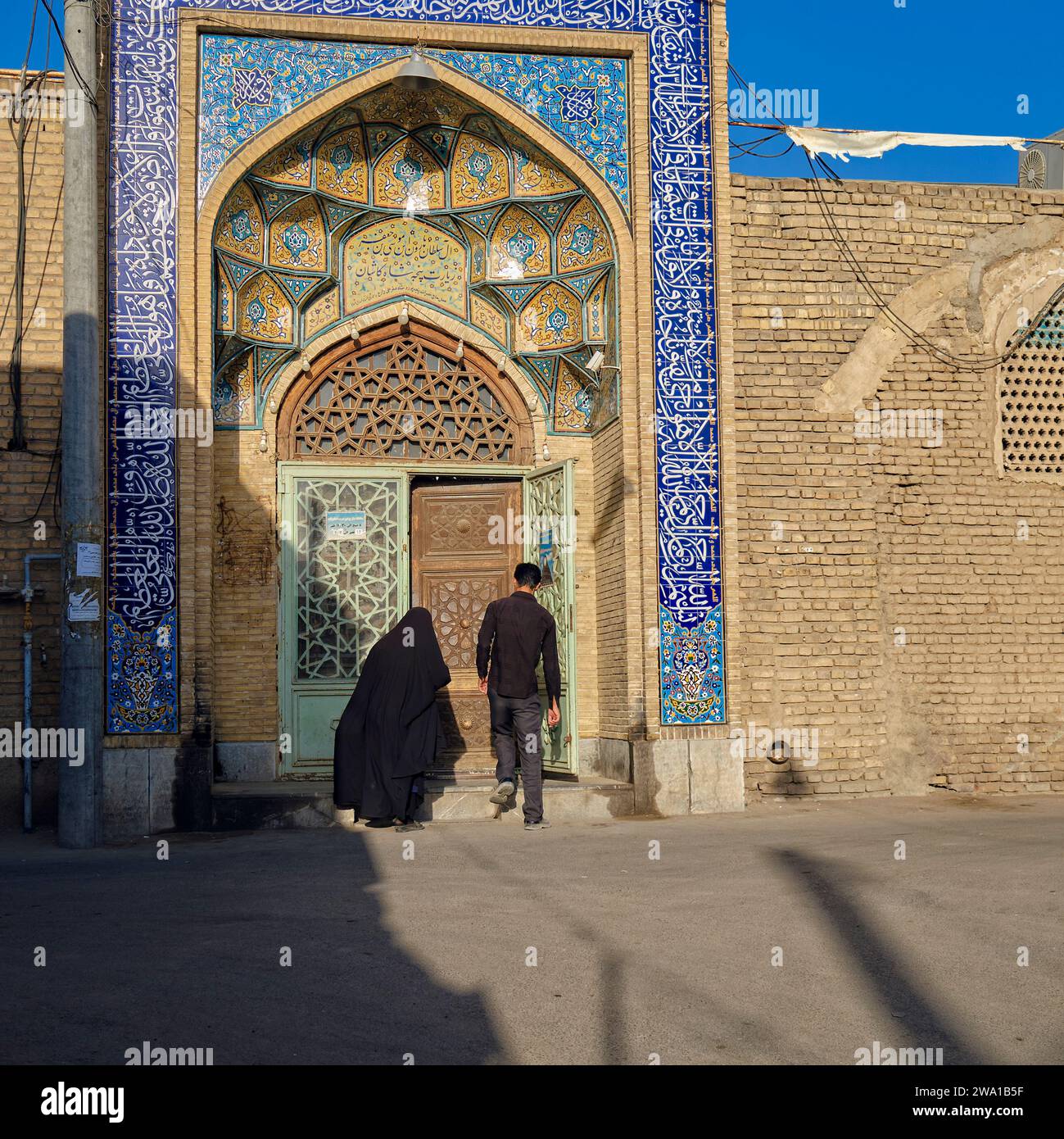 Local man and woman step into the Sultan Amir Ahmad Shrine, one the ...
