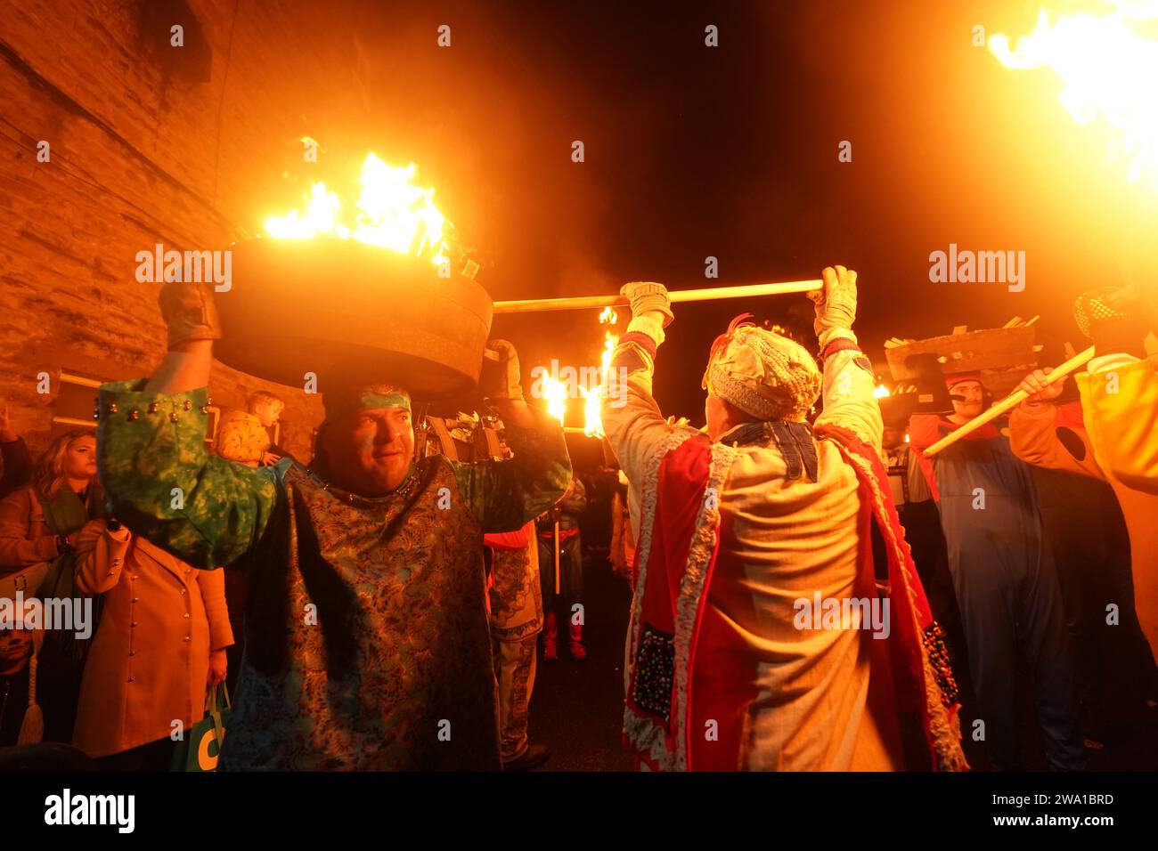 Men, known as guisers, carry burning whisky barrels through the streets ...