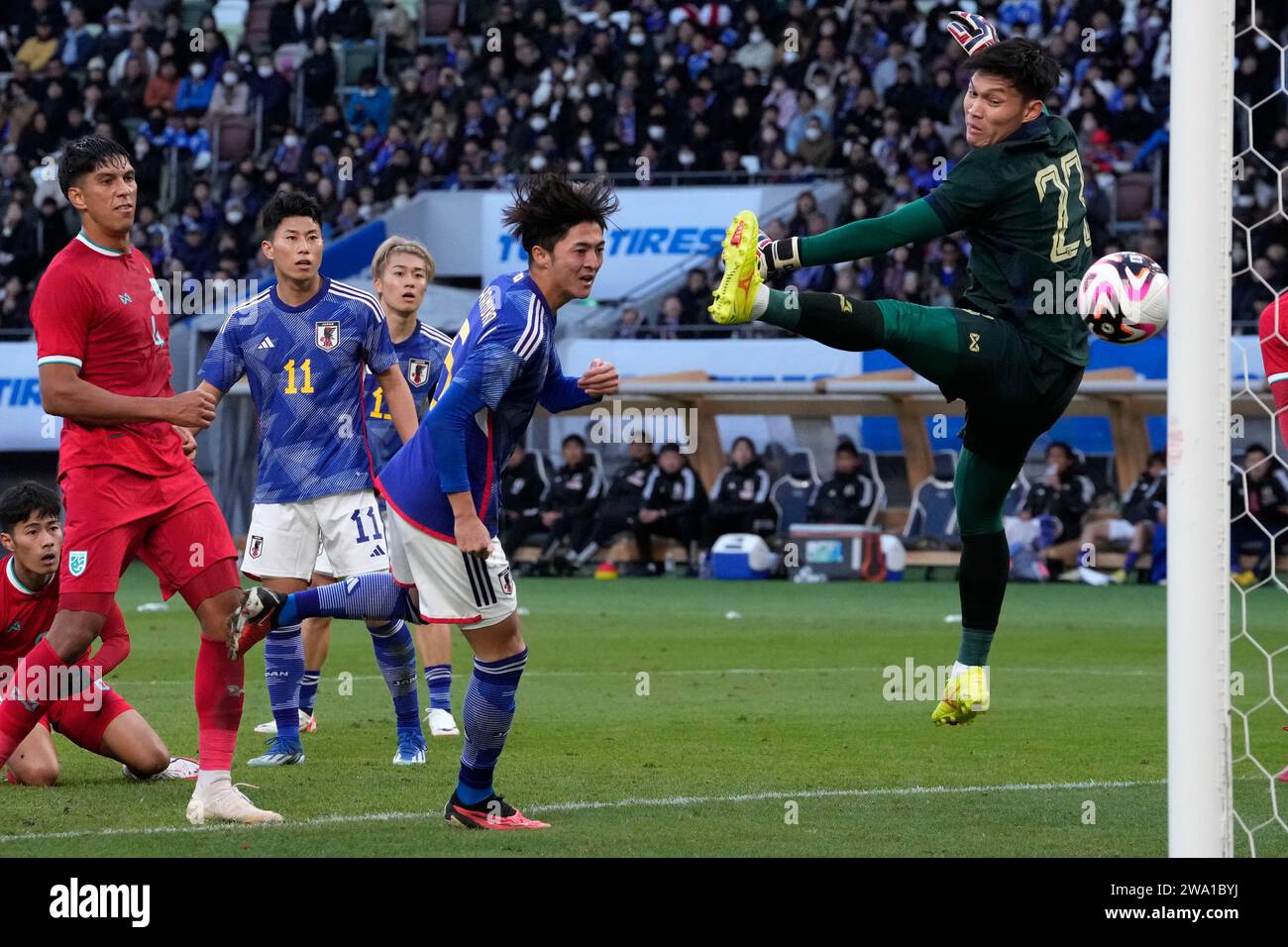 Takumu Kawamura, center, of Japan, scores a goal against goalkeeper Patiwat Khammai of Thailand ...