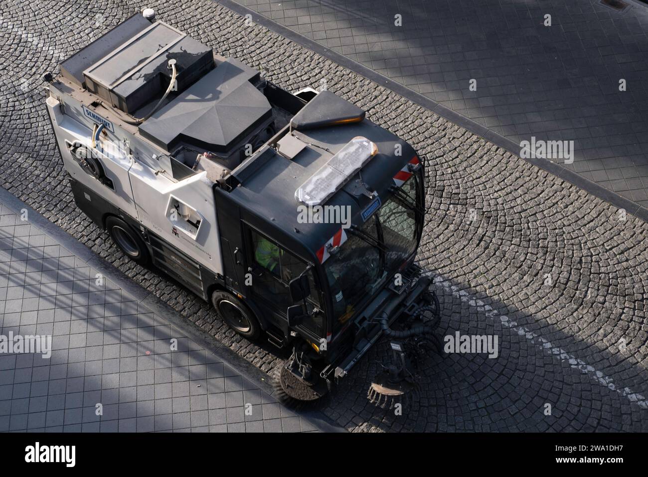 Street cleaning machine gathers trash, garbage and leaves, seen from ...