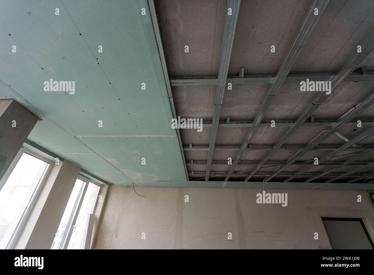 Construction worker assemble a suspended ceiling with drywall and ...