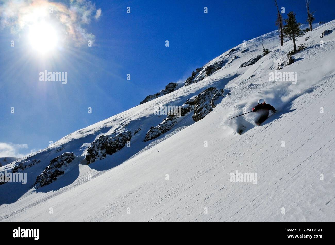 A man skiing on a bluebird powder day at a mountain resort near South ...