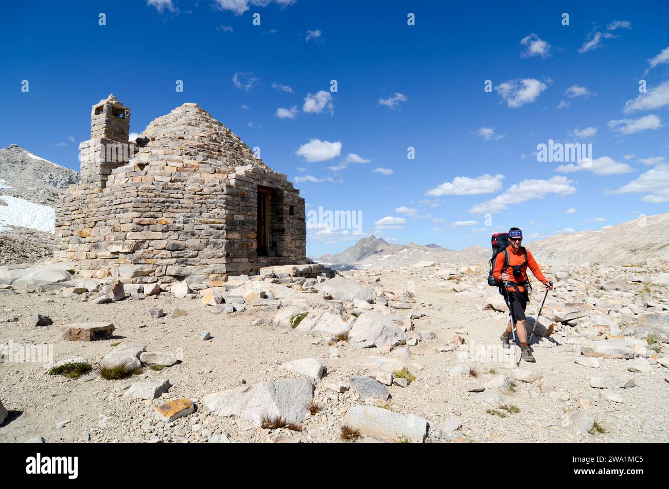 A backpacker walks by the famous Muir Hut on the top of Muir Pass on ...