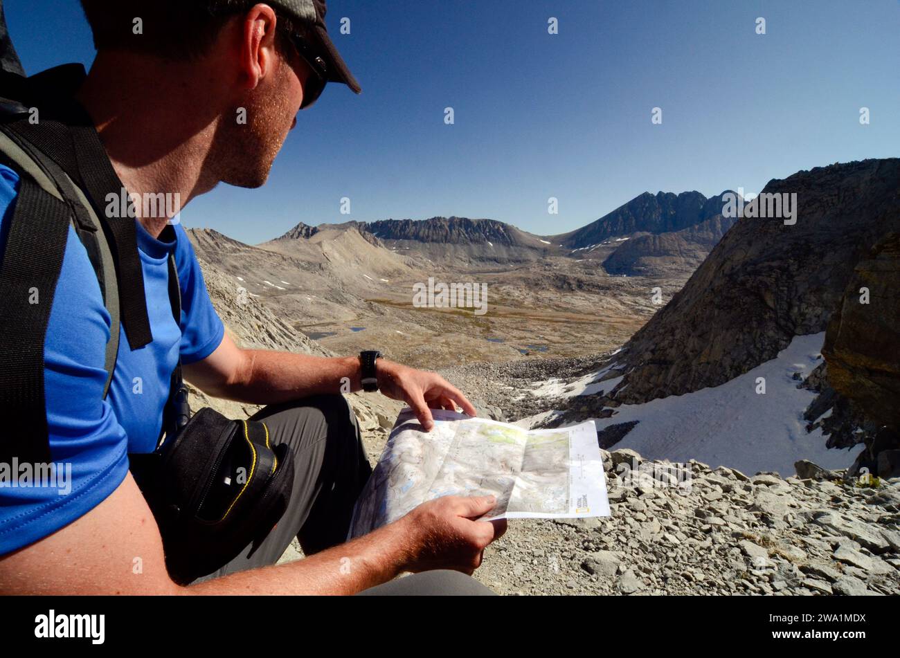A man uses a topographic map to navigate from the top of Frozen Lake ...