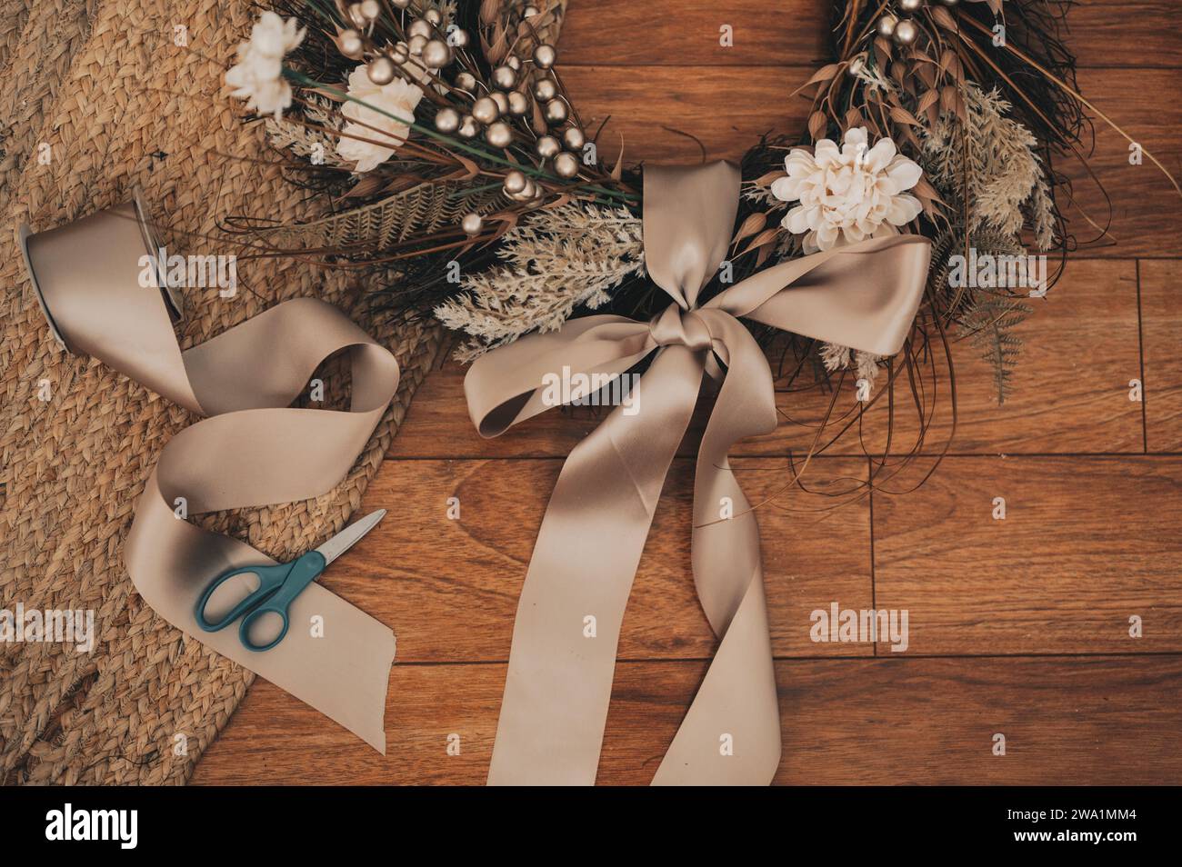 Modern rustic wreath with beige ribbon and scissors Stock Photo - Alamy