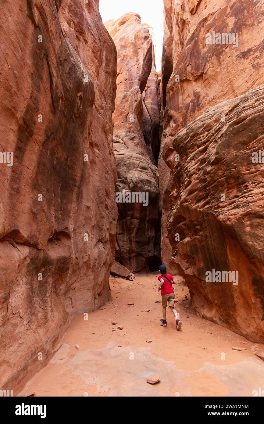 Tourist Boy Hiking through Narrow Sandstone Desert Rock Canyon Trail in ...