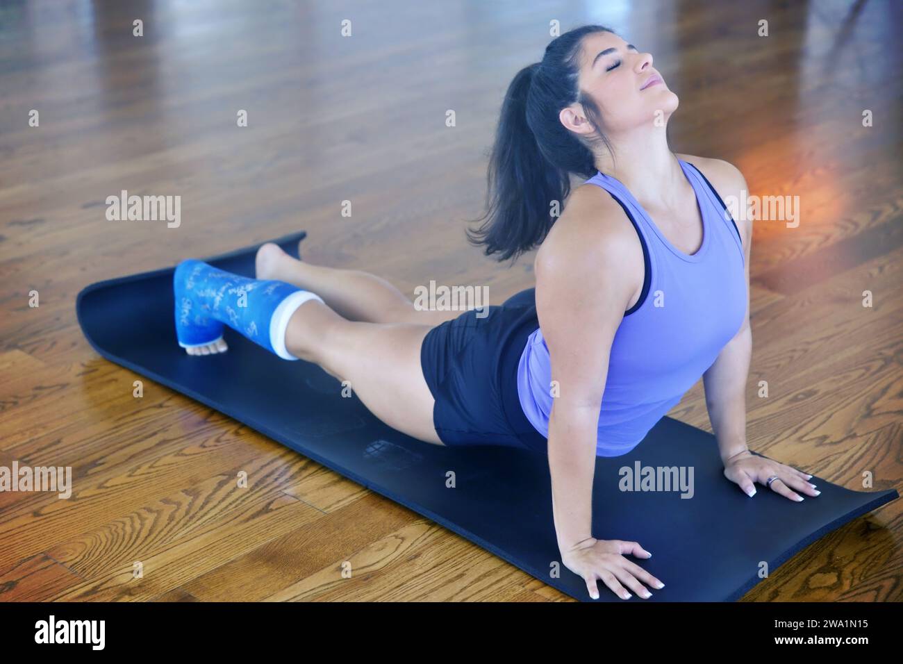 Woman does Yoga with Broken Leg to build strength Stock Photo - Alamy