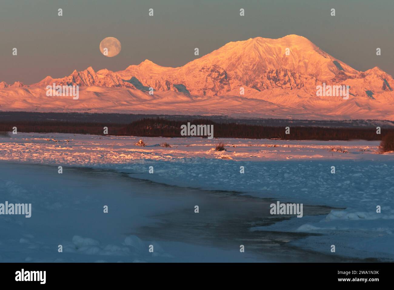 Full moon sets behind the Alaska Range with Mt Foraker Stock Photo - Alamy