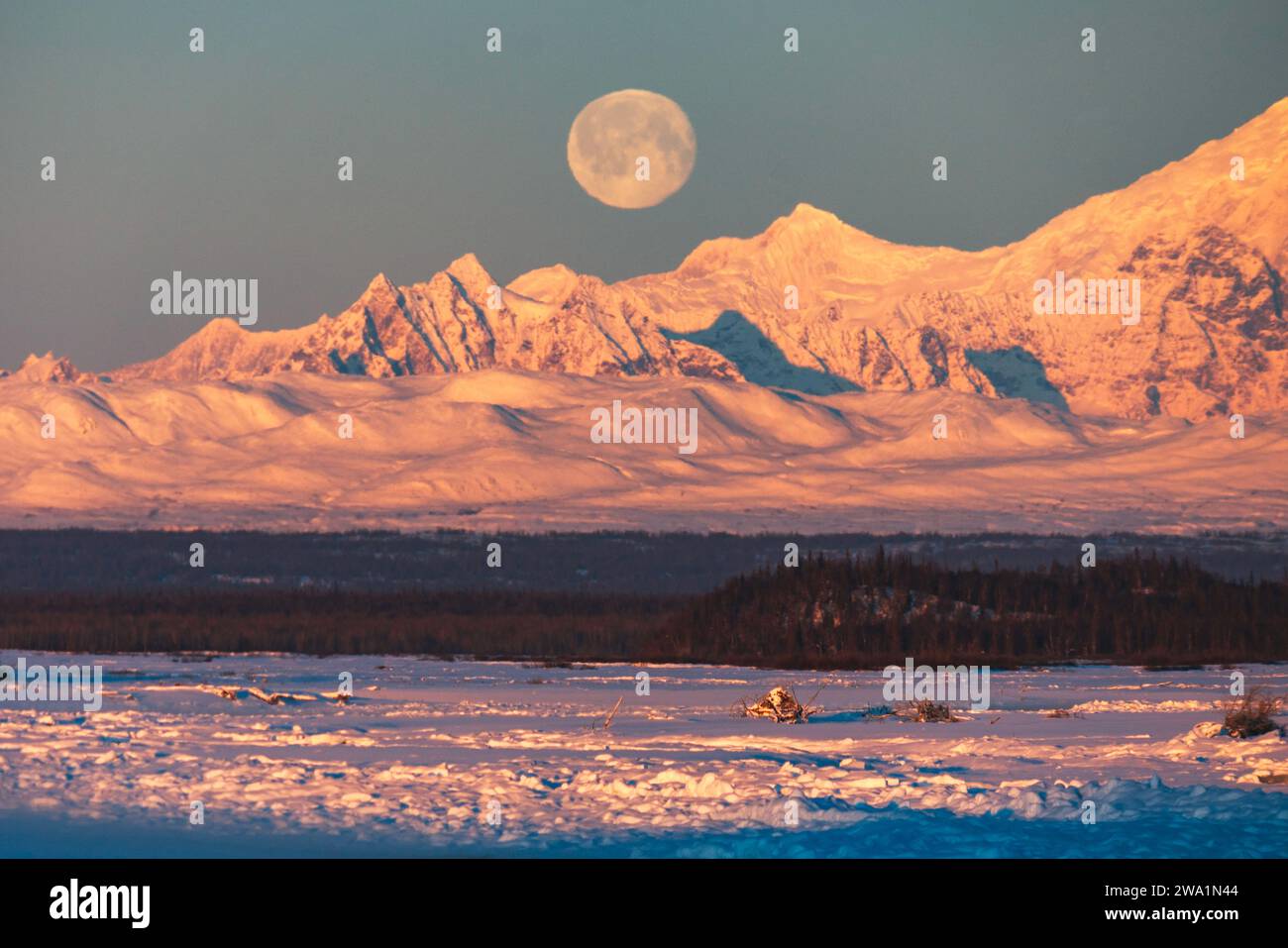 Full moon sets behind the Alaska Range with Mt Foraker Stock Photo - Alamy