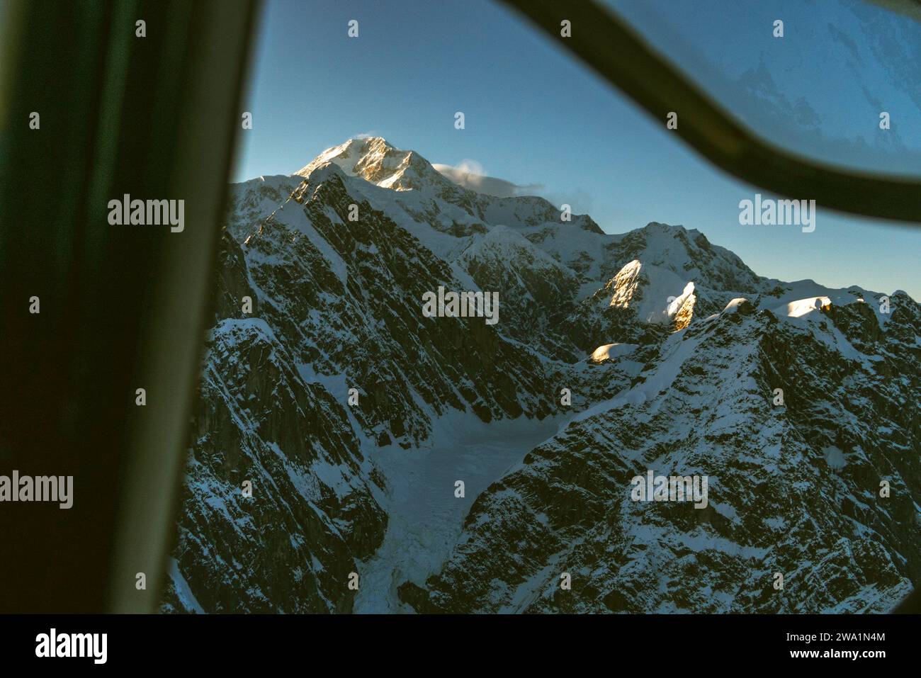 Alpenglow at sunset through an airplane window with Denali in Alaska ...