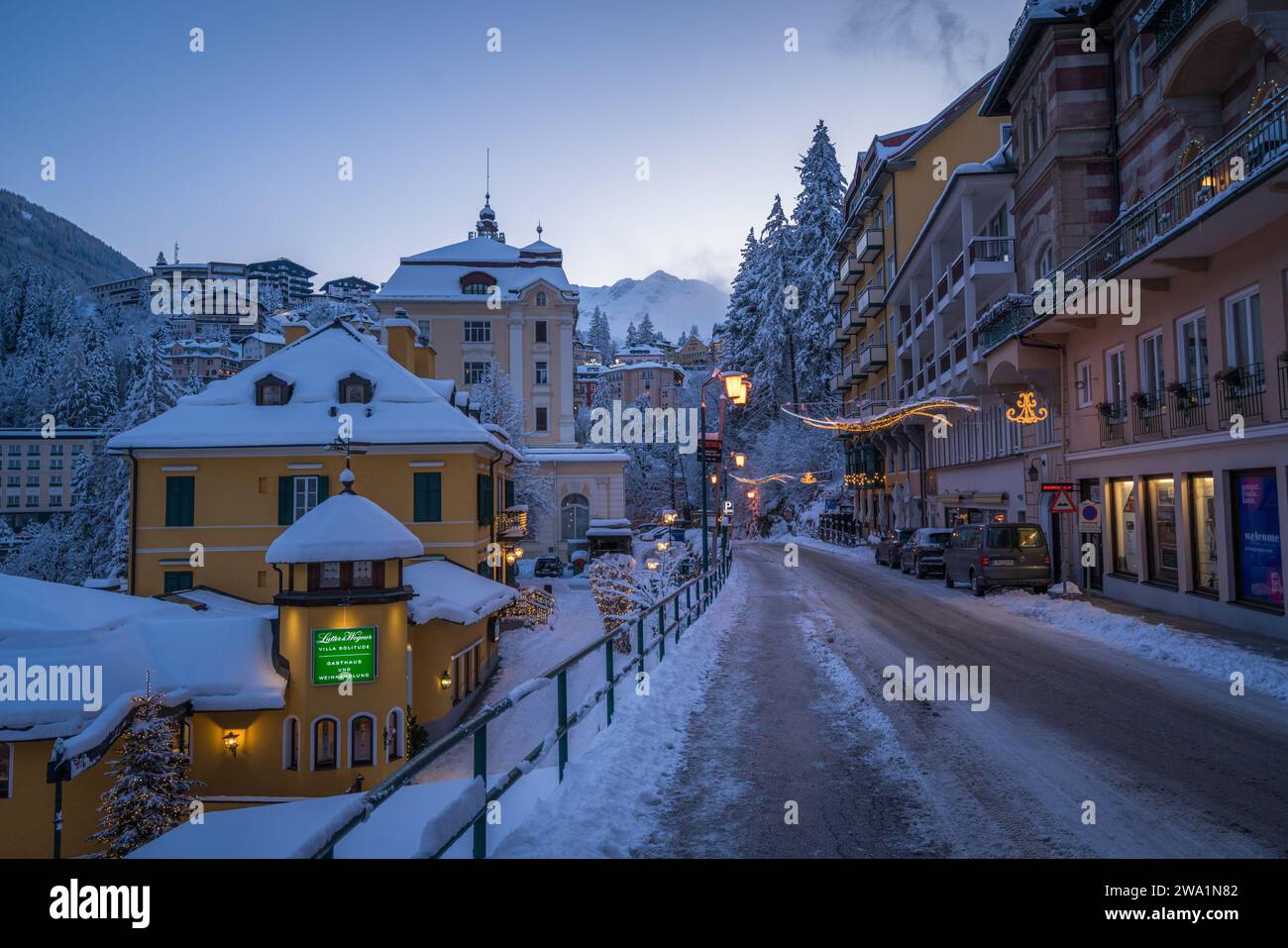 Blue hour in snowy Austrian village with mountains in the distance ...