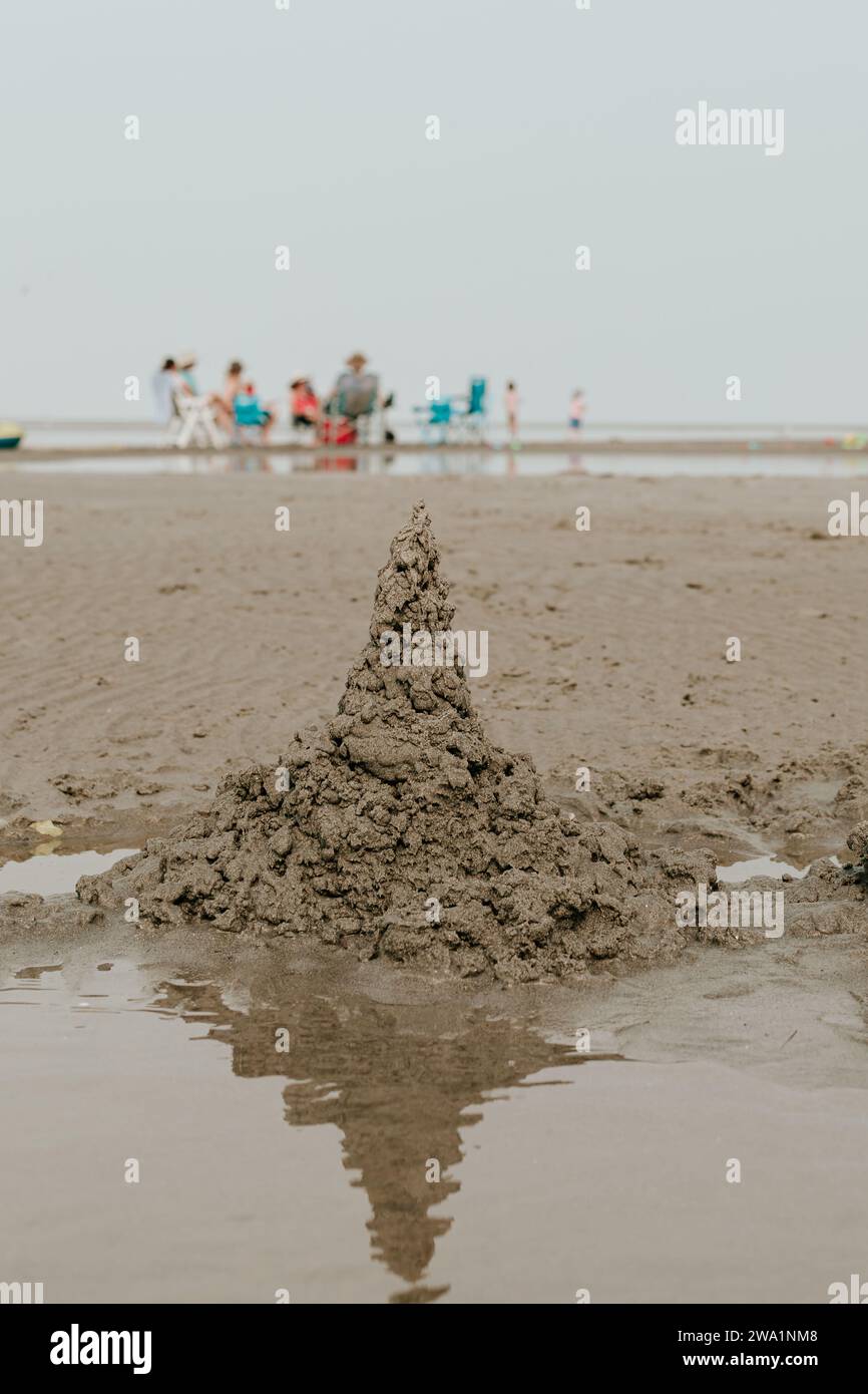 A sand drip castle on the shore at the beach during summer Stock Photo ...