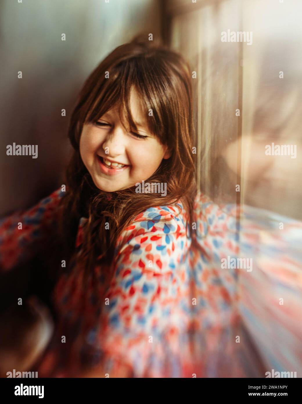 Girl sitting next to window smiling and laughing Stock Photo - Alamy