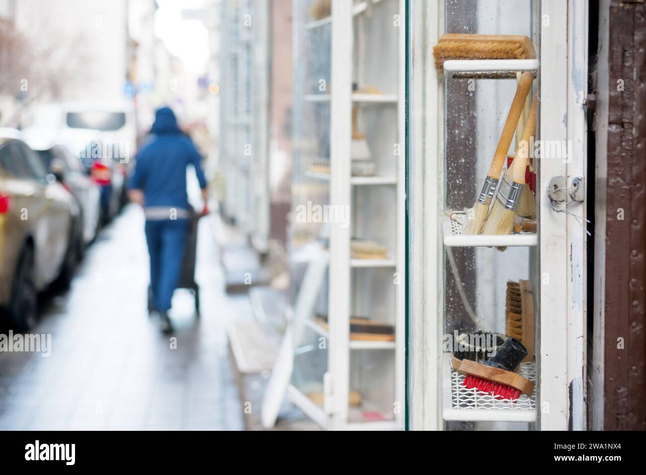 Brushes in a store window, person carrying trolley Stock Photo - Alamy
