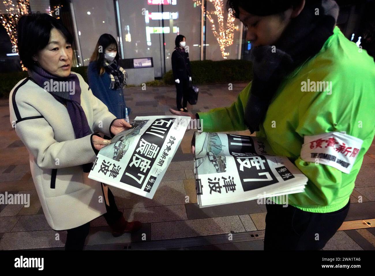 People receive extra edition of Yomiuri Shimbun newspaper reporting the ...