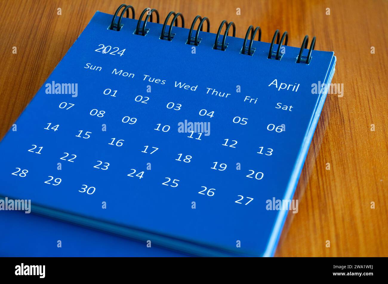 April 2024 table calendar on wooden desk. Time and calendar concept ...