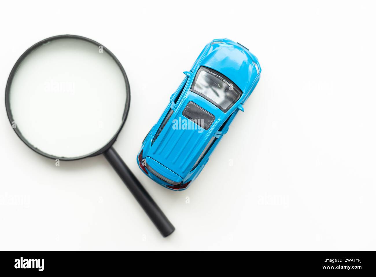 Toy car model and magnifying glass on white background Stock Photo - Alamy