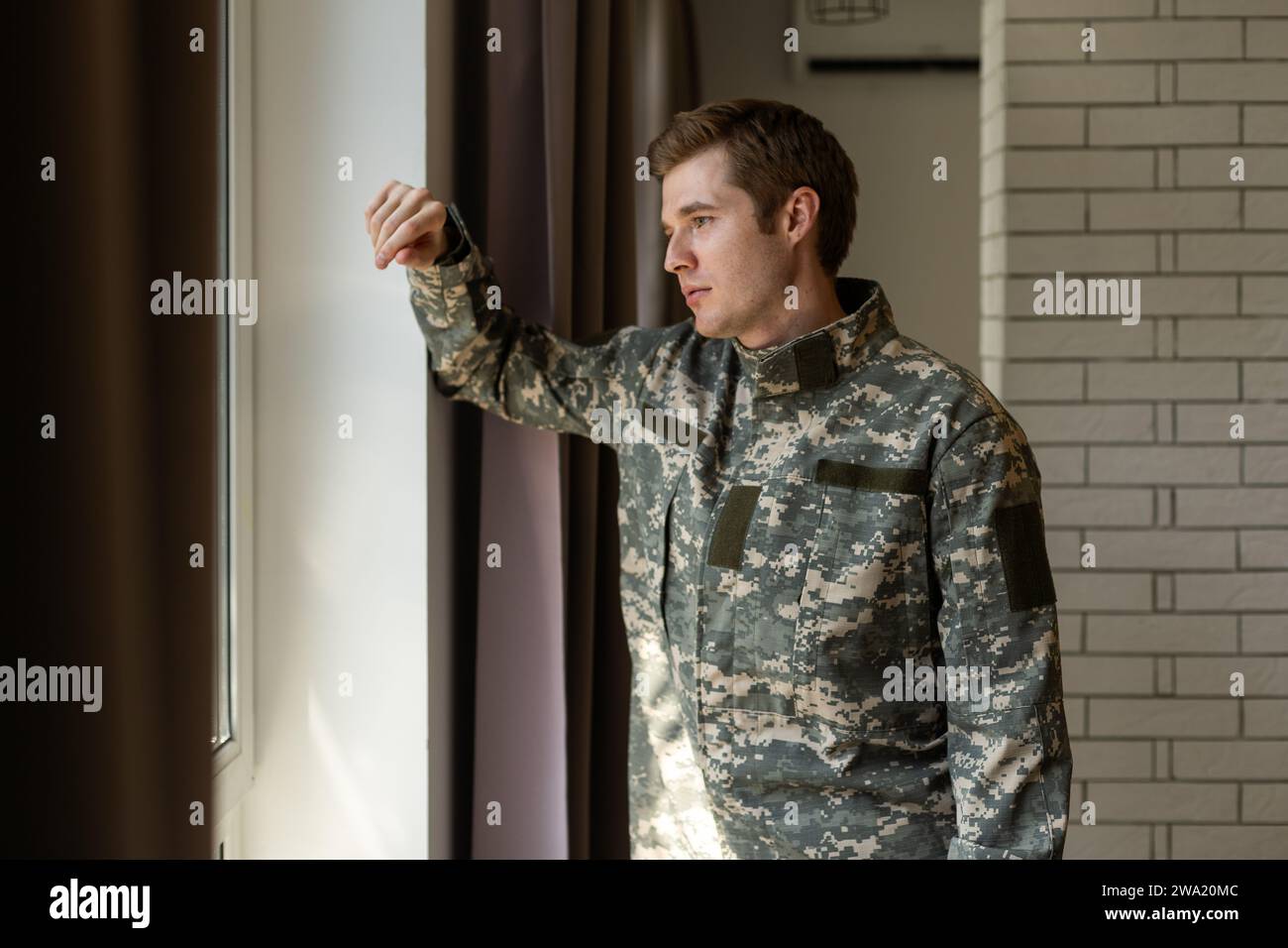 Depressed and sad soldier in green uniform with trauma after war ...