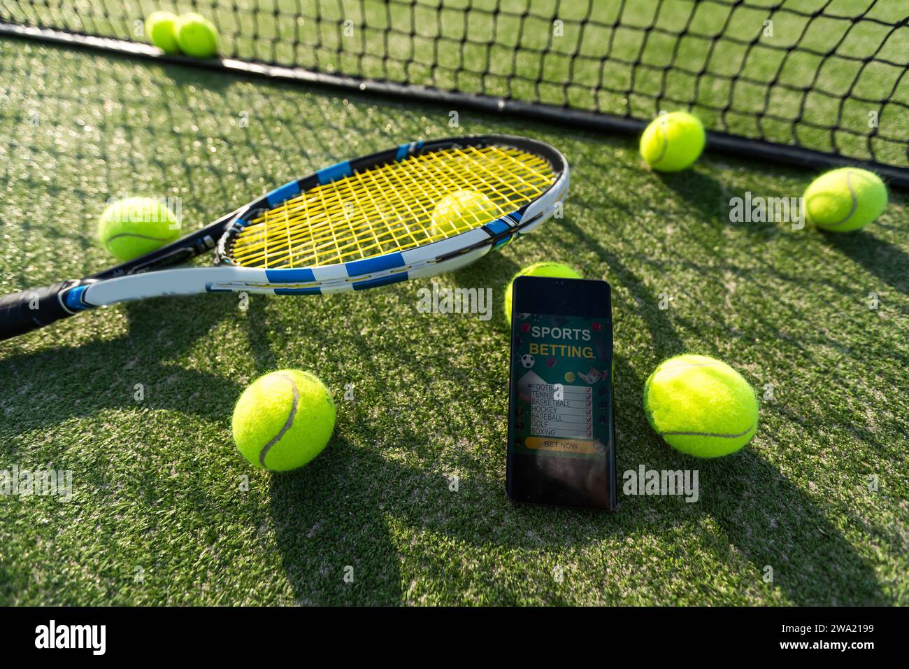 A tennis ball, a racket and a mobile phone with a put screen lie on a ...