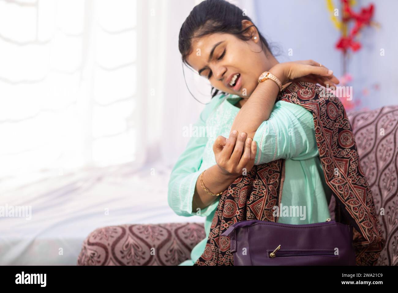 An Indian woman holding her elbow for pain showing painful expression ...